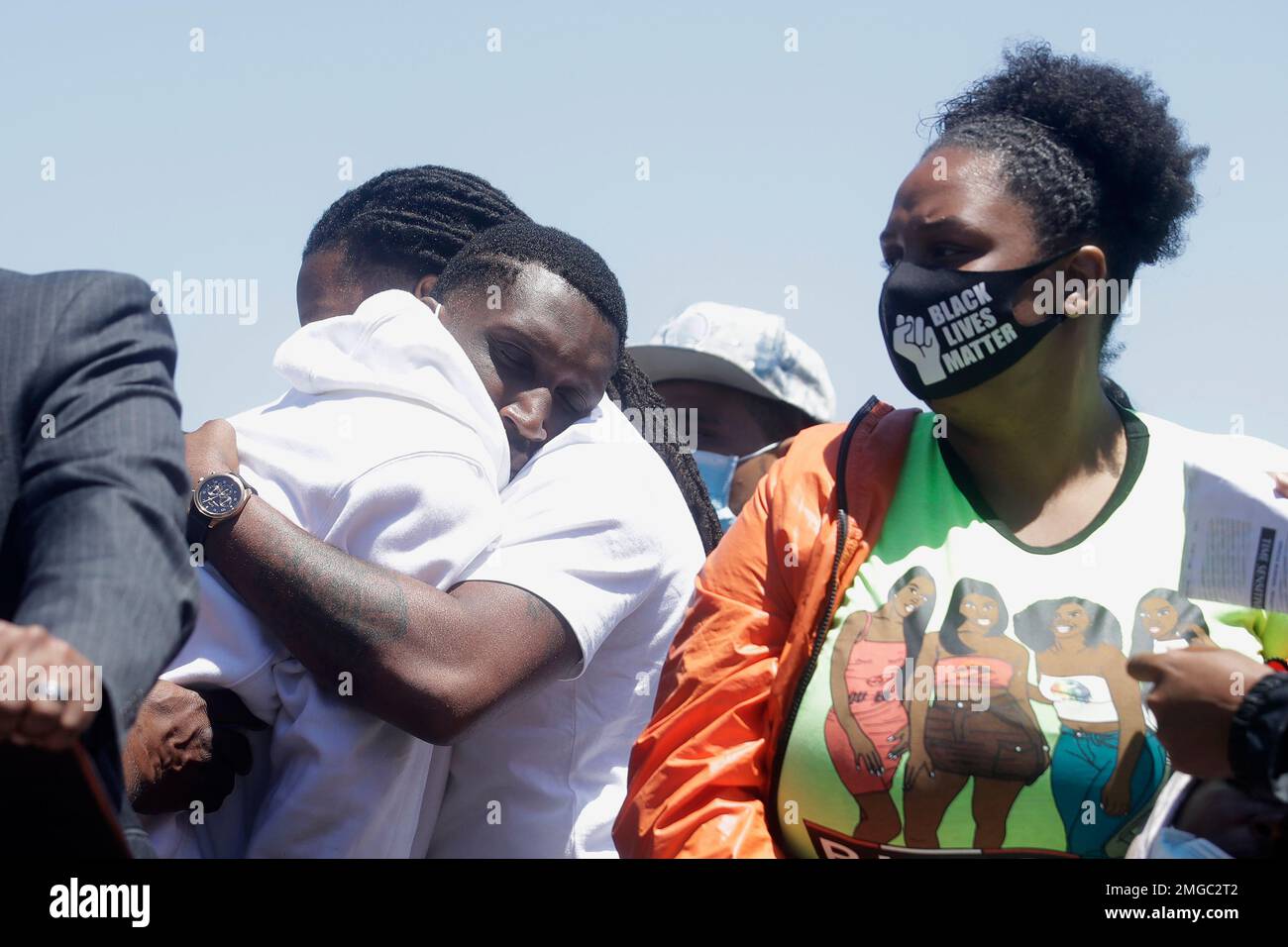 Jason Young, left, is hugged by a man after speaking at a news ...