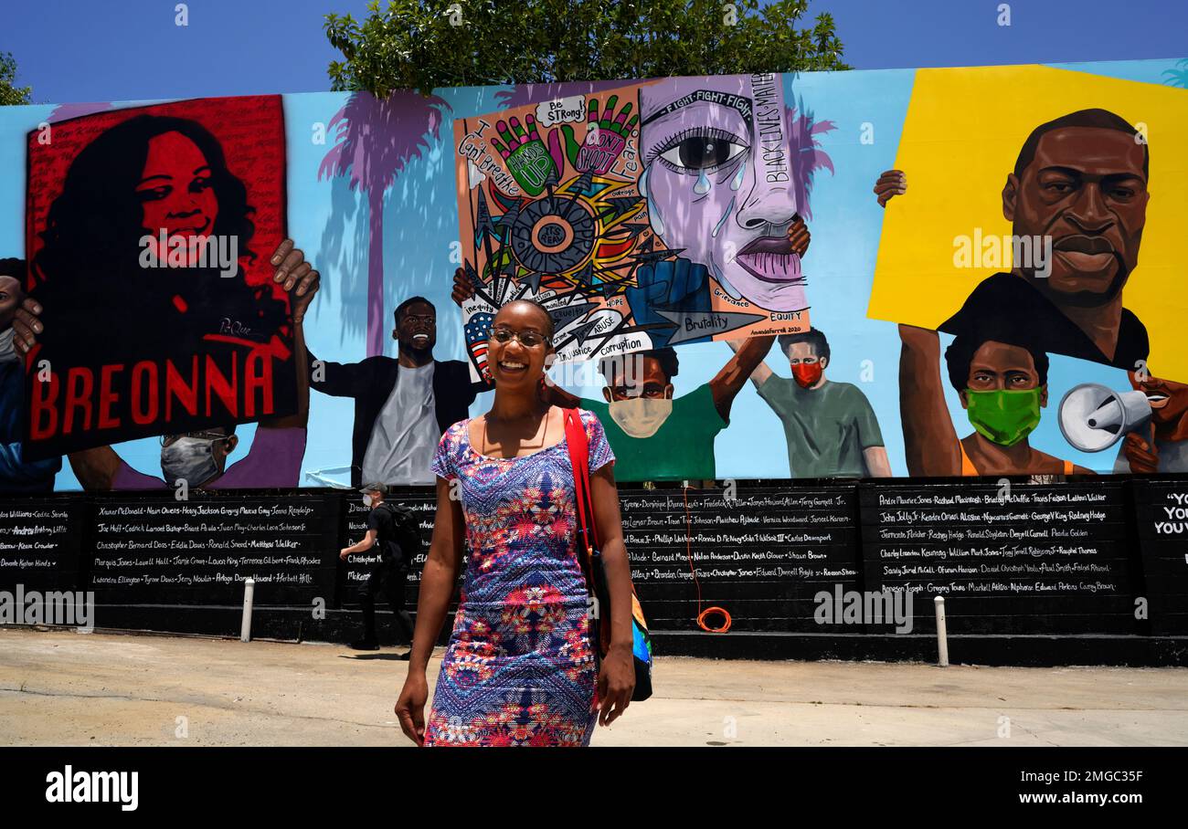 Artist Amanda Ferrell Hale, stands by a section of a mural she painted ...
