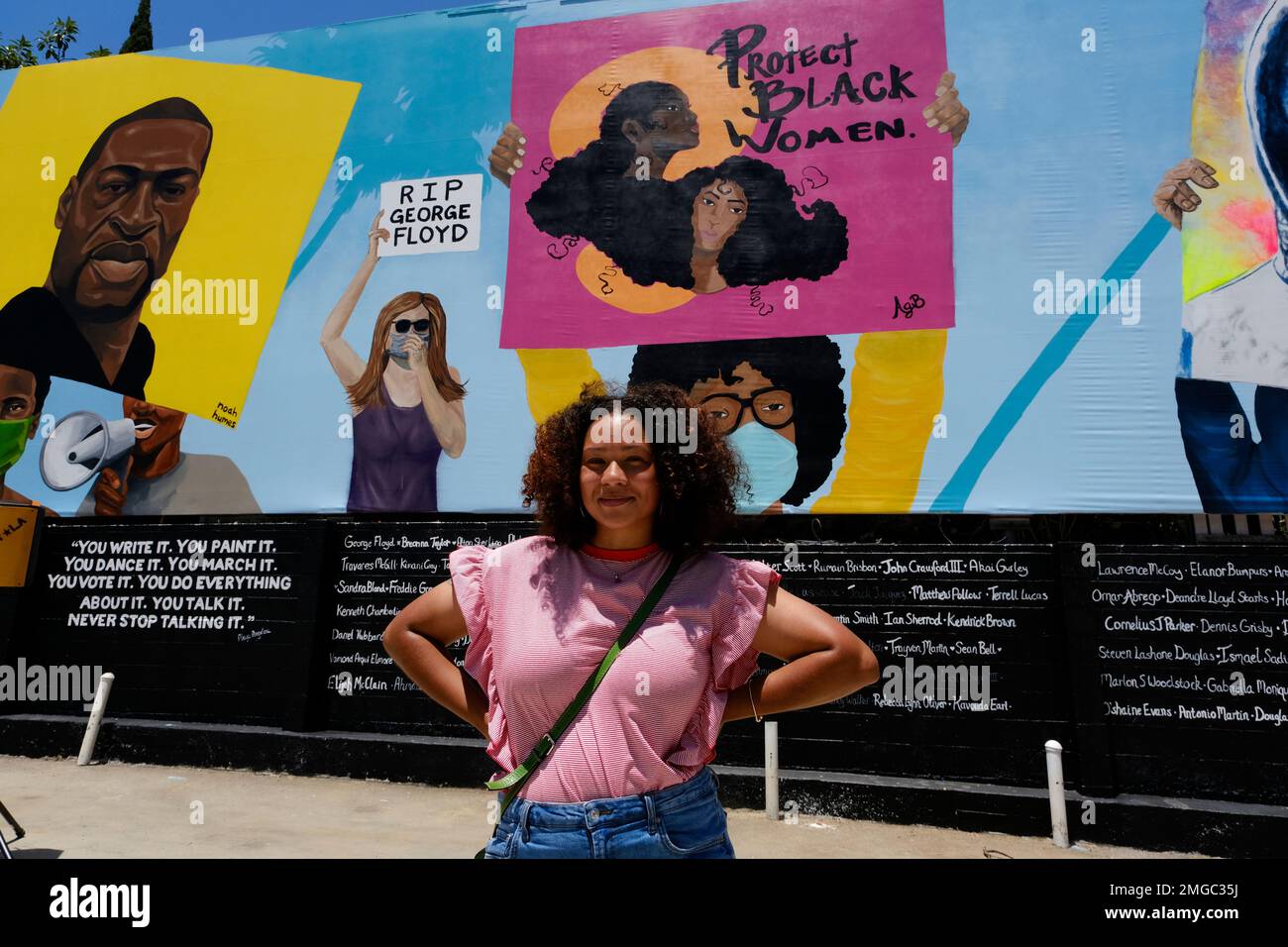 Artist Alexandra Allie Belisle, stands by a section of a mural she ...