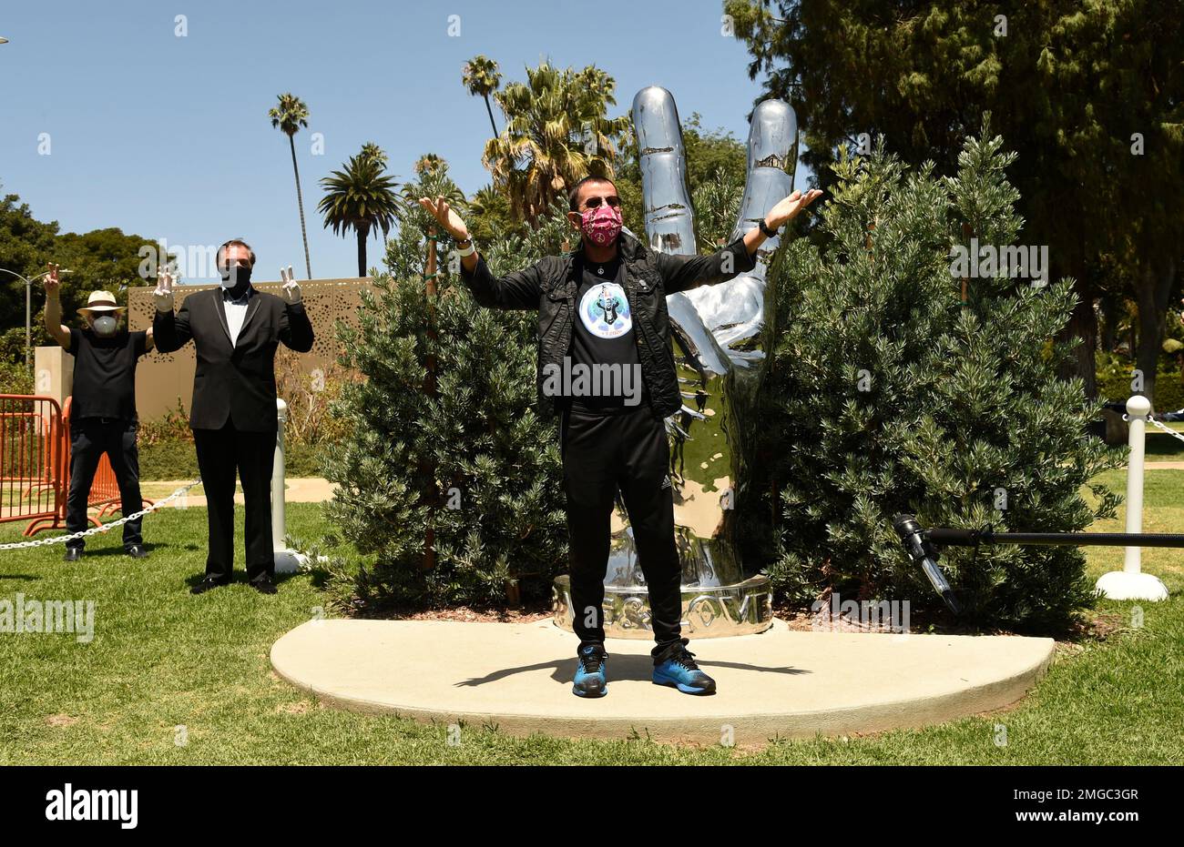 Musician Ringo Starr poses in front of his "Peace and Love" sculpture ...