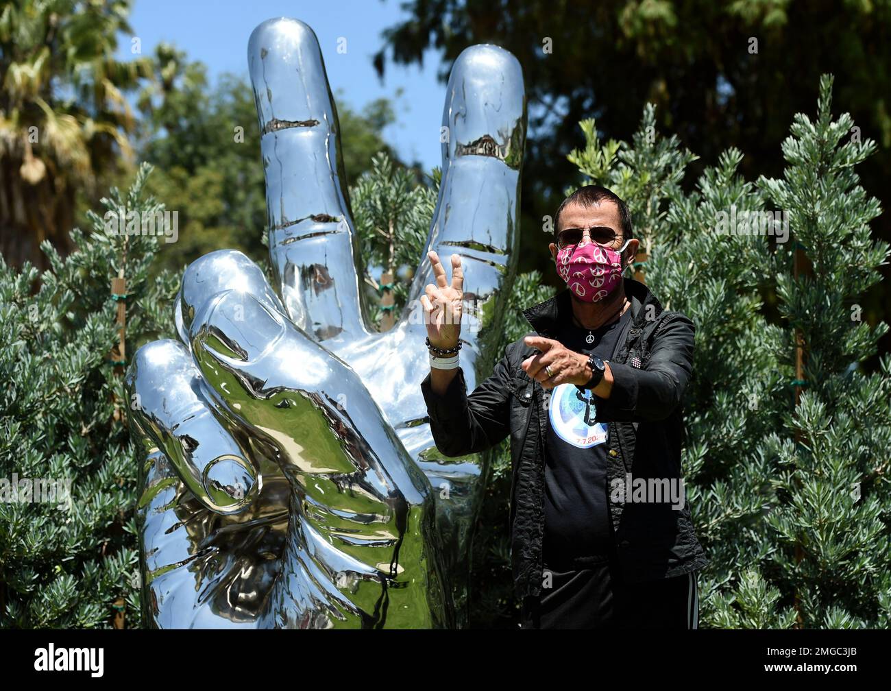 Musician Ringo Starr poses in front of his "Peace and Love" sculpture ...