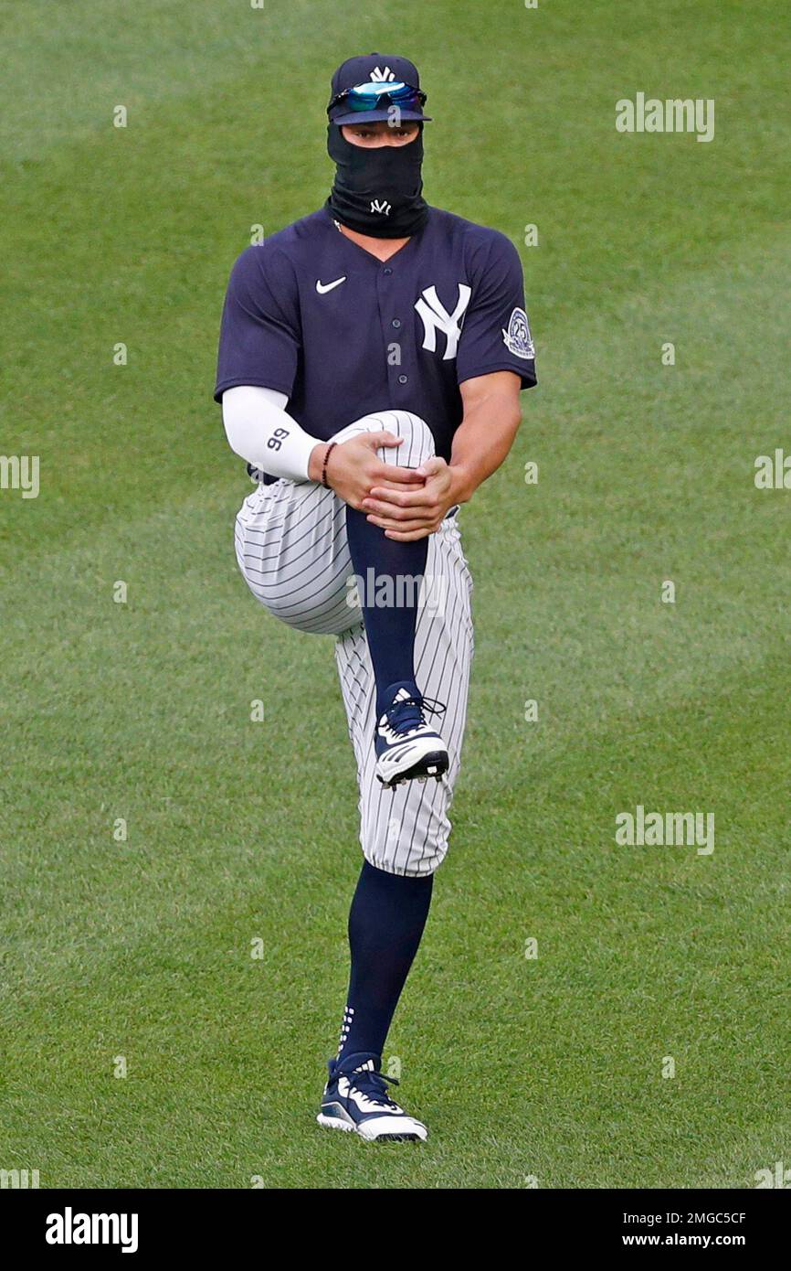 New York Yankees' Aaron Judge stretches wearing a balaclava before an ...