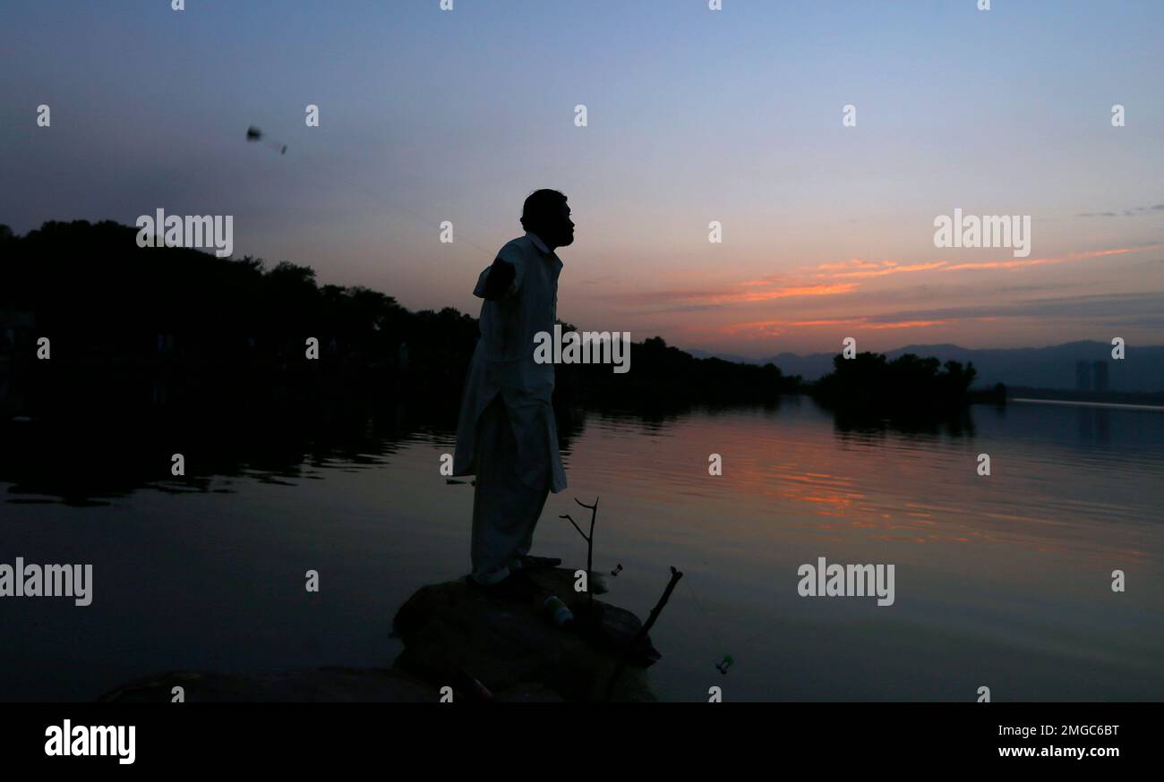 A Pakistani fishes at Rawal Lake in the suburb of the Pakistani capital ...