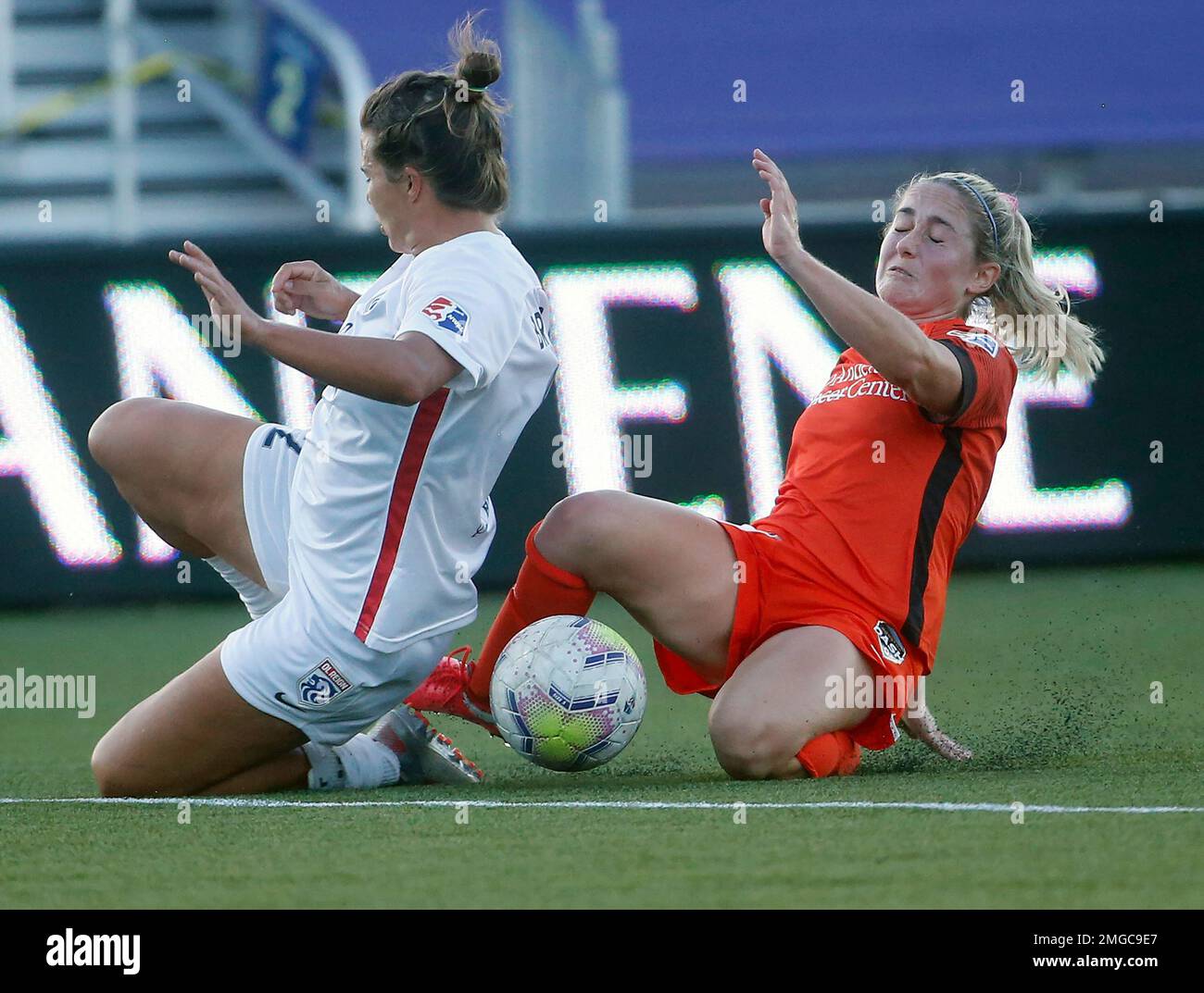 OL Reign defender Amber Brooks, left, defends against Houston Dash ...