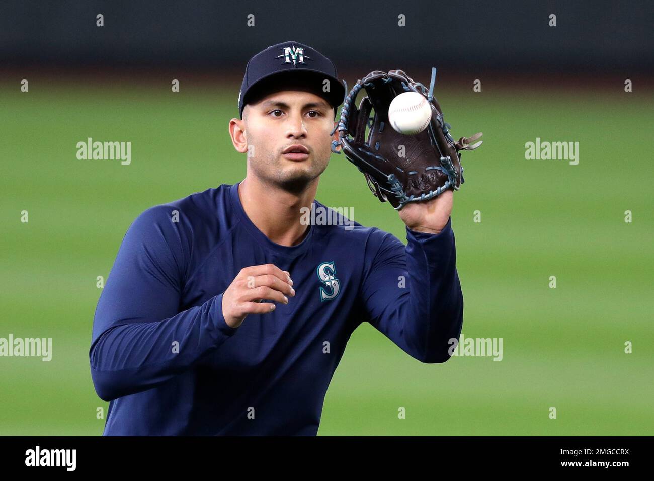 Seattle Mariners infielder Tim Lopes reaches to catch a ball at a ...