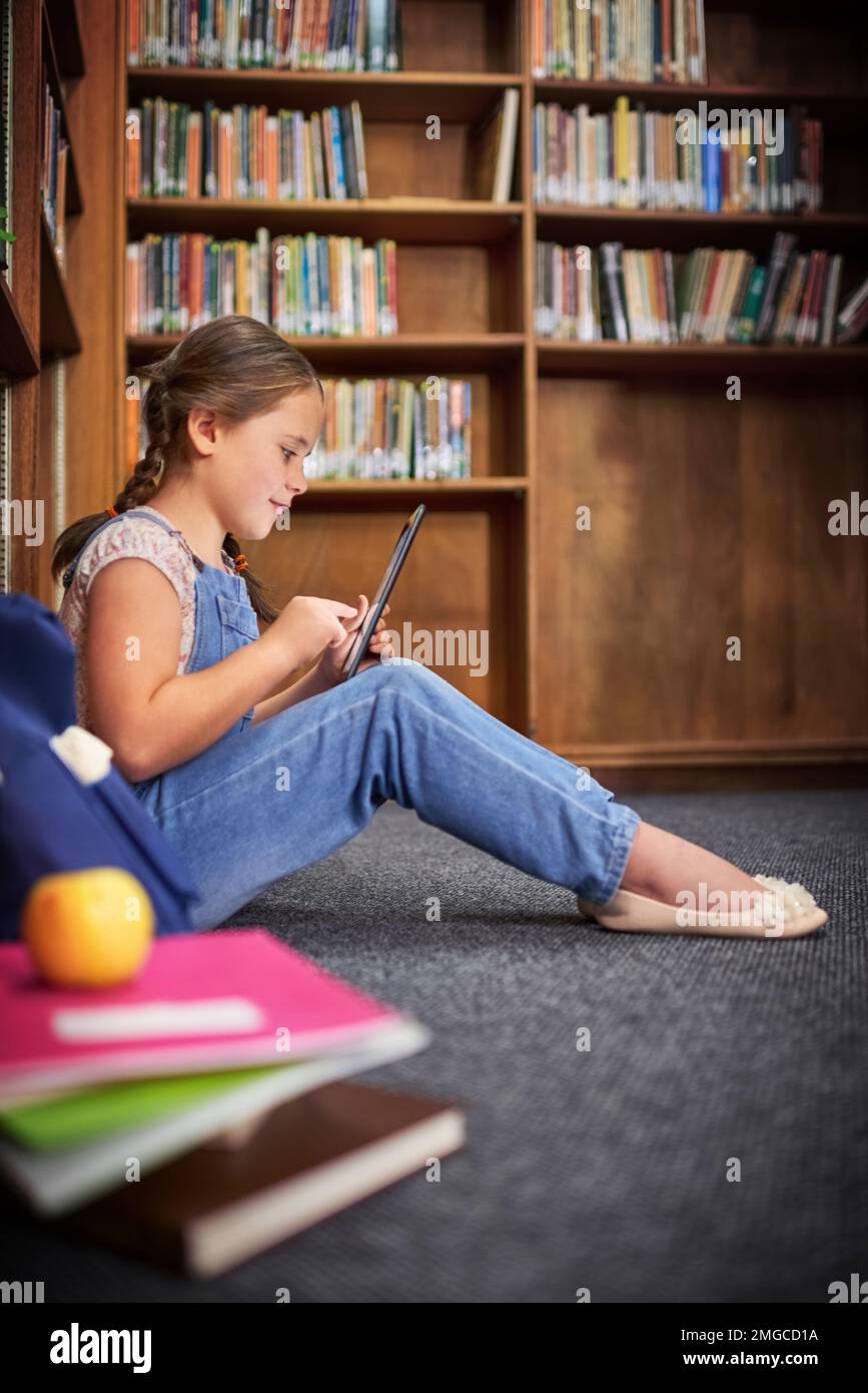 Developing through the digital age. a young girl using a digital tablet ...