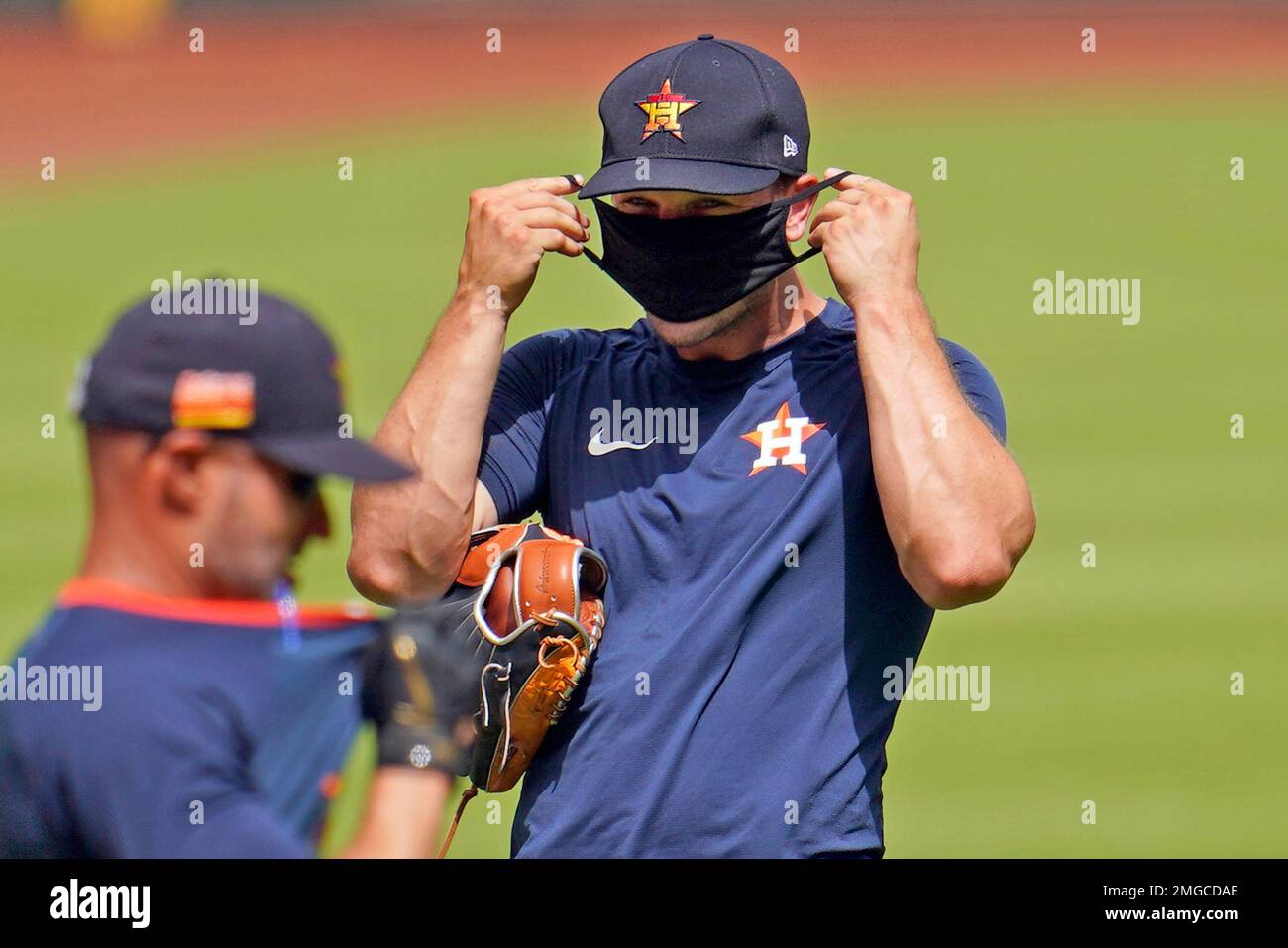 Houston Astros third baseman Alex Bregman, right, puts on a mask during ...