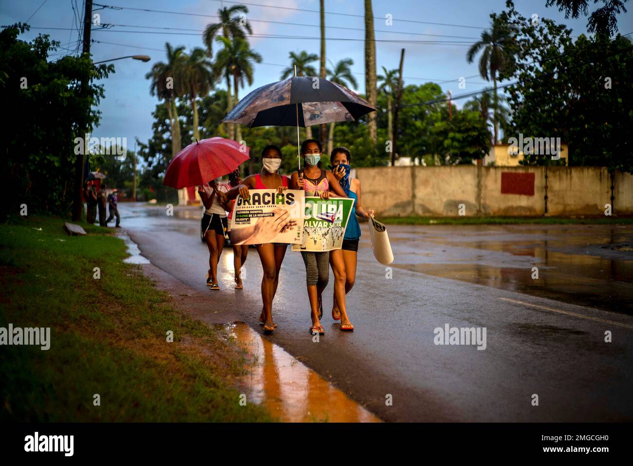Girls carry posters under the rain to welcome the Cuban medical brigade ...