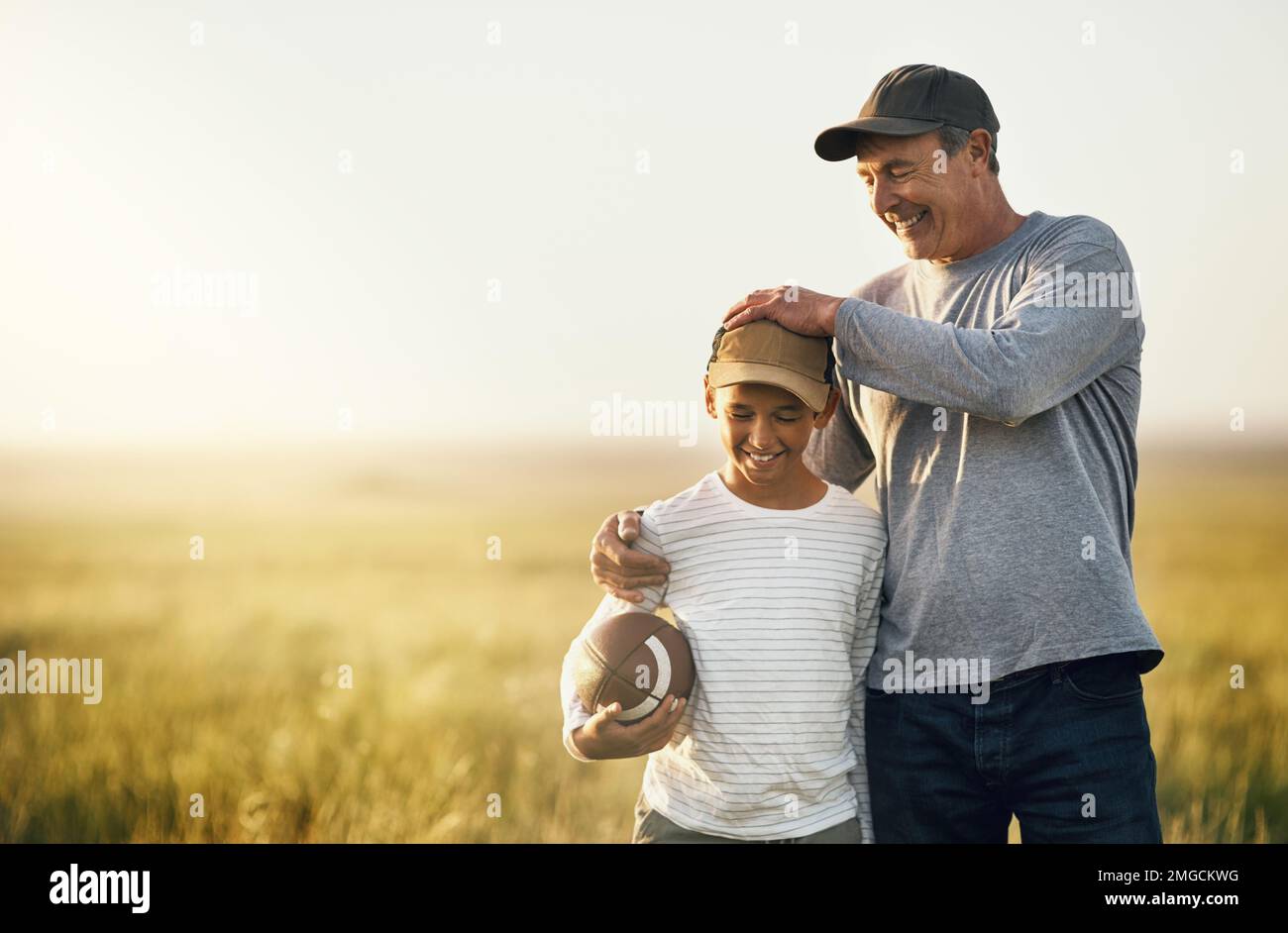 We love the excitement of the game. father and son playing football on an open field Stock Photo ...