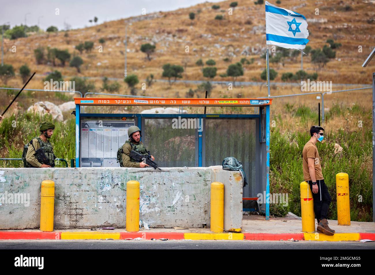 Israeli soldiers guard a bus station at the Tapuach junction next to ...