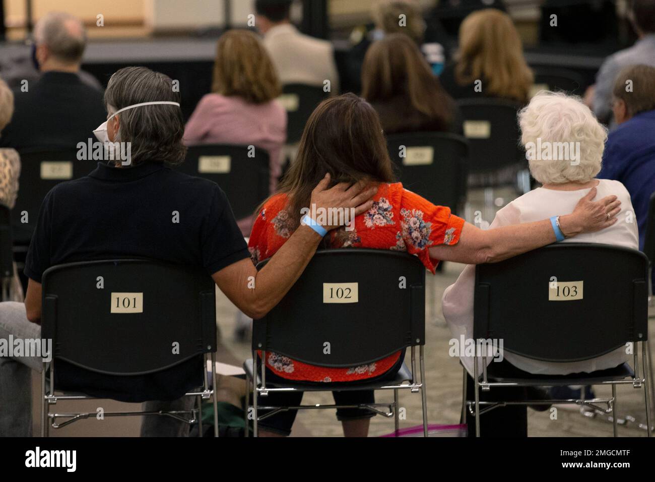 Sandy James, center, accompanied by her husband, Brian, left, and ...