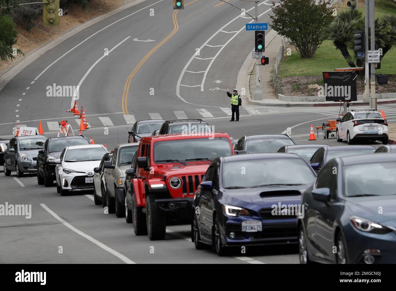 A traffic officer directs traffic at a coronavirus testing site at ...