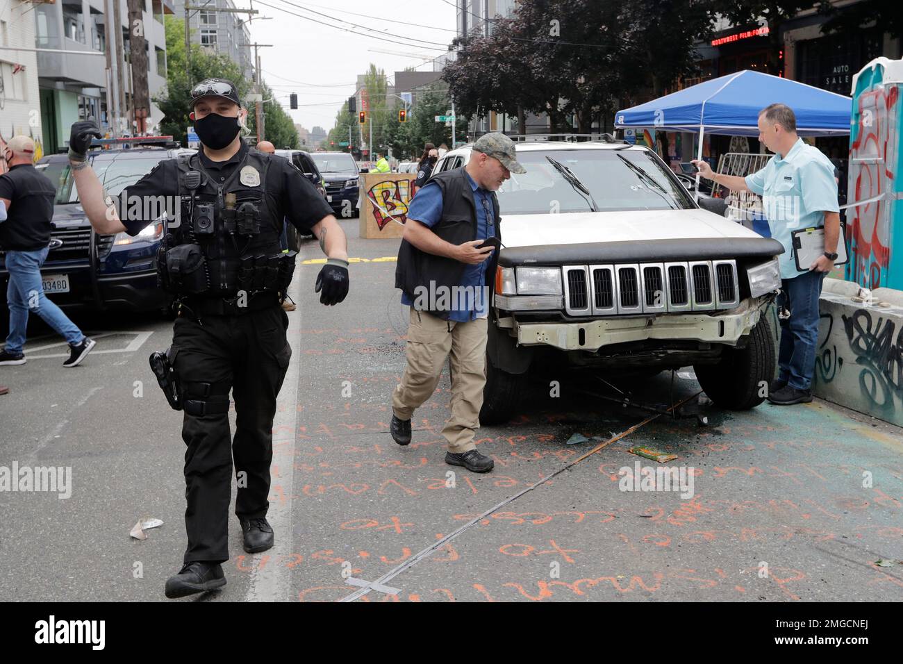 A Seattle police officer asks people to move aside to allow police ...