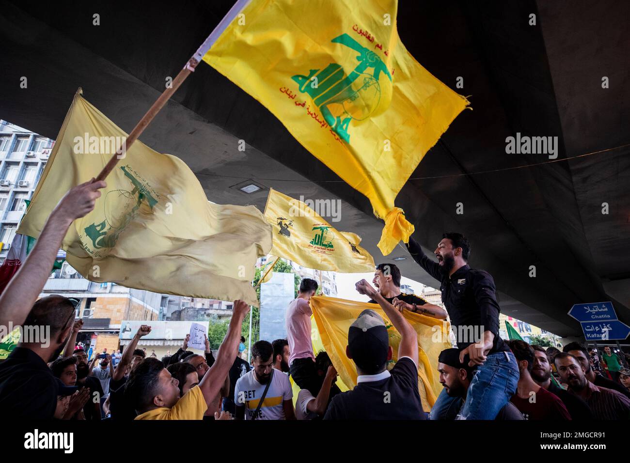 Hezbollah and Amal supporters wave Hezbollah and Iranian flags as they ...