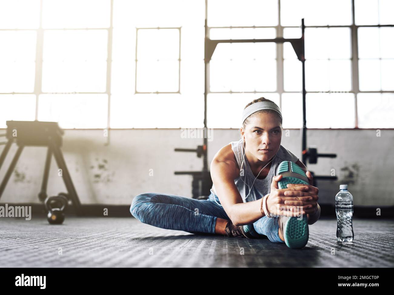 Today I am working out my legs. an attractive young woman stretching at ...