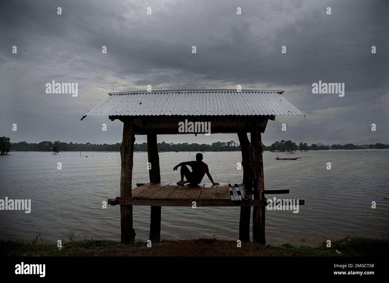 In this June 26, 2020, photo, an Indian man sits in a shack next to ...