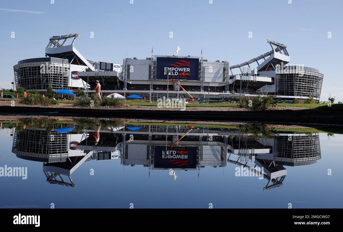 Workers toil on the new sign on the south side of Empower Field at Mile ...