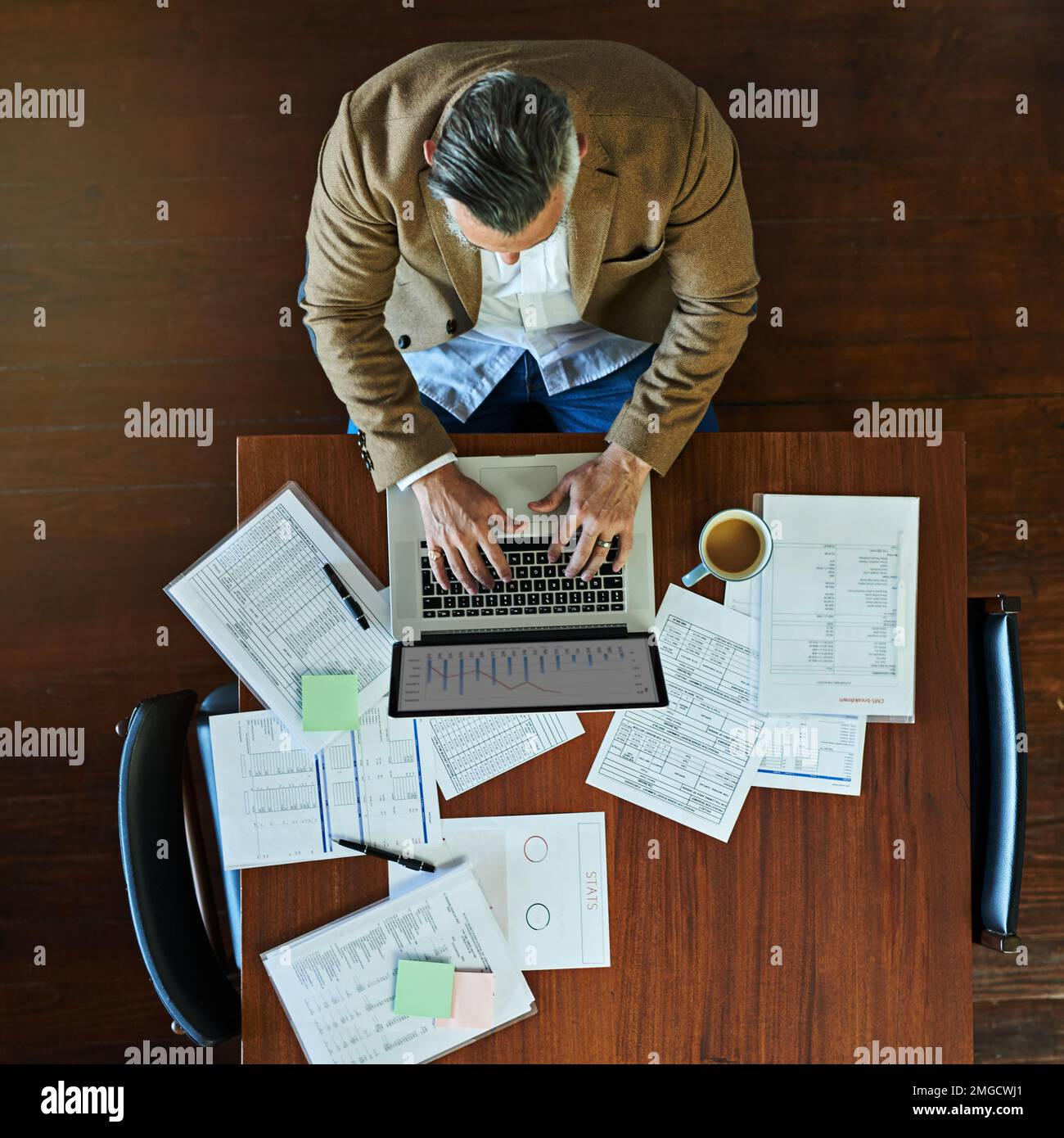 Keeping business moving along. High angle shot of a mature businessman ...