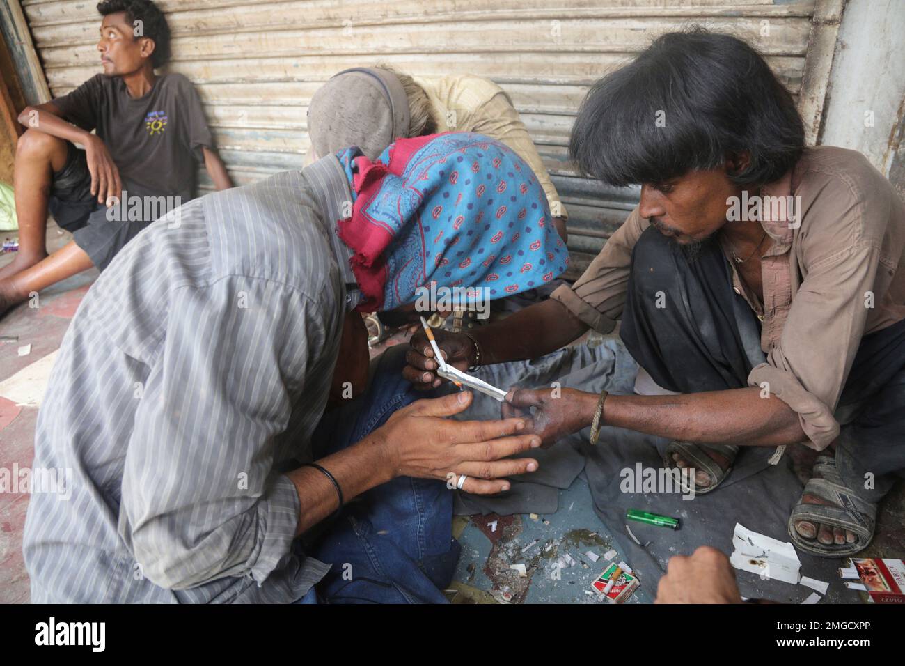 A Pakistani sniffs heroin at a roadside in Karachi, Pakistan, Friday ...