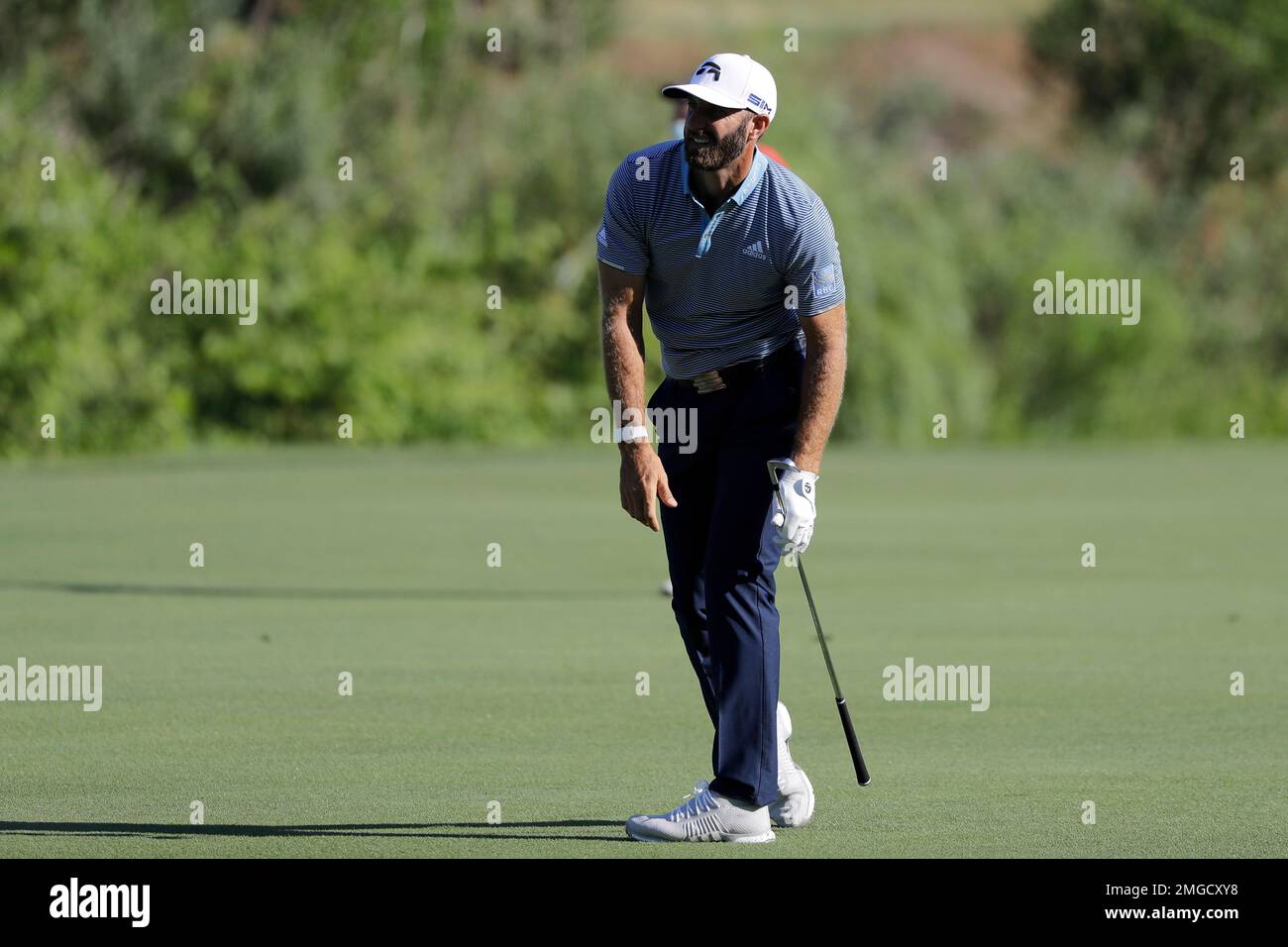 Dustin Johnson watches his shot from the 13th hole fairway during the ...