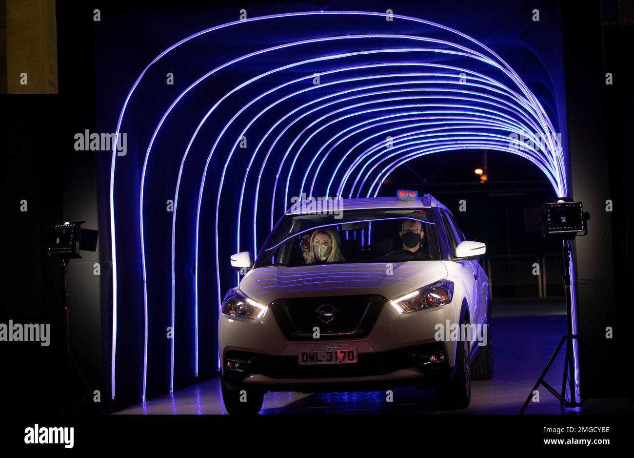 A couple enters through a lighted gateway into a drive-in installed at ...