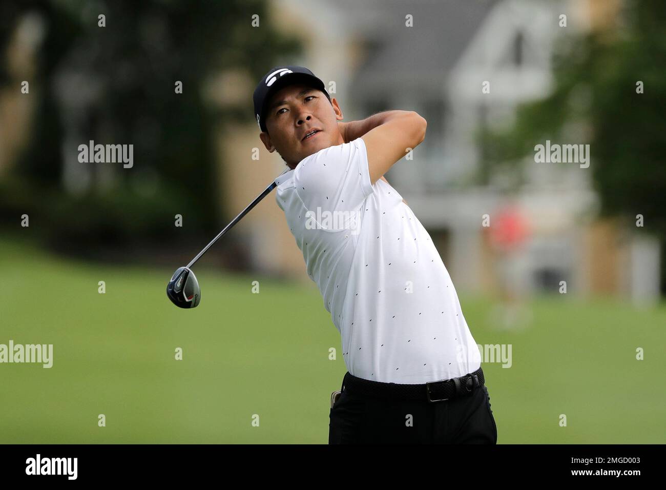 Xinjun Zhang, of China, tees off on the third hole during the first ...