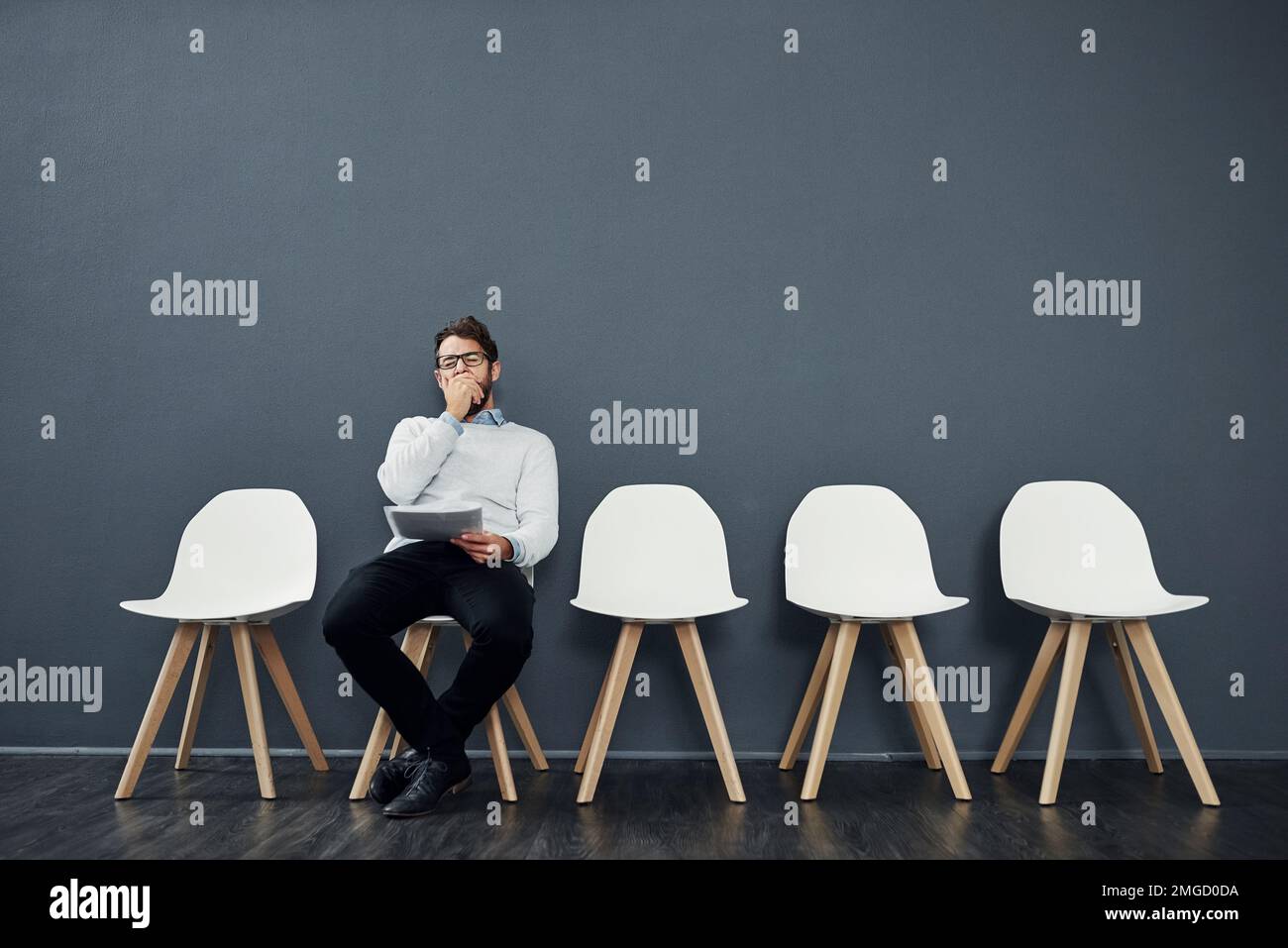 Man this wait is long. a handsome young man yawning while waiting in ...