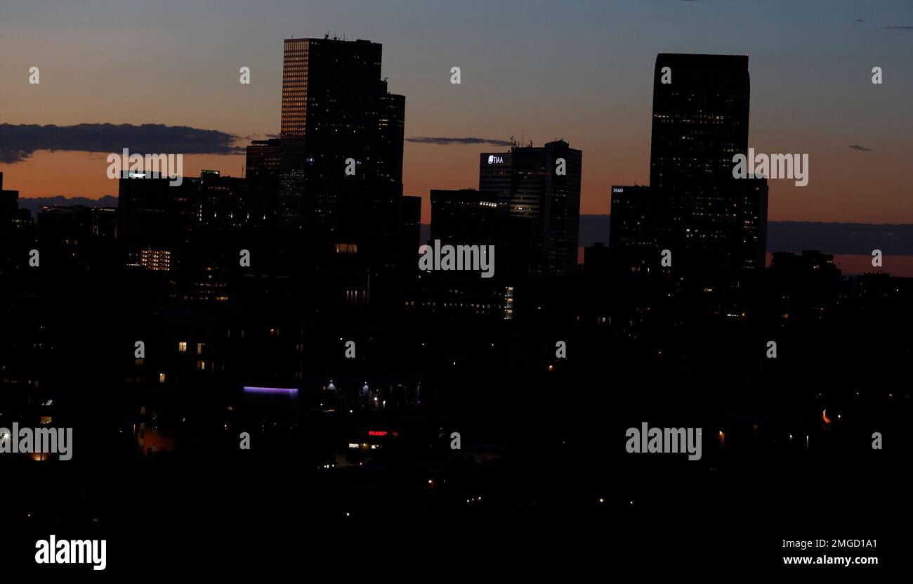 The setting sun sends a streak of light behind the skyline late Tuesday ...