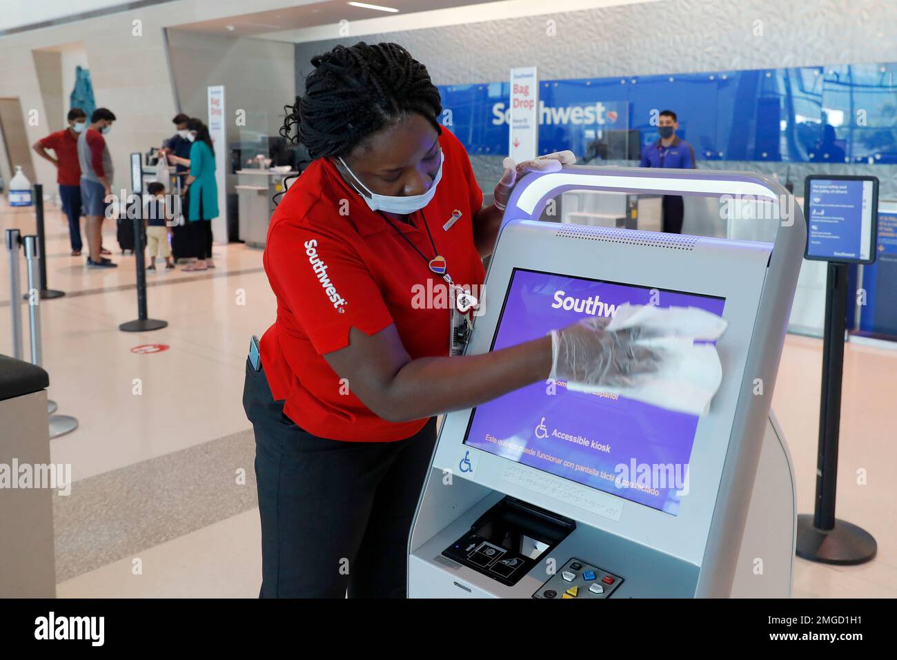 Southwest Airlines employee La Toya Malone Key wipes down a kiosk after ...