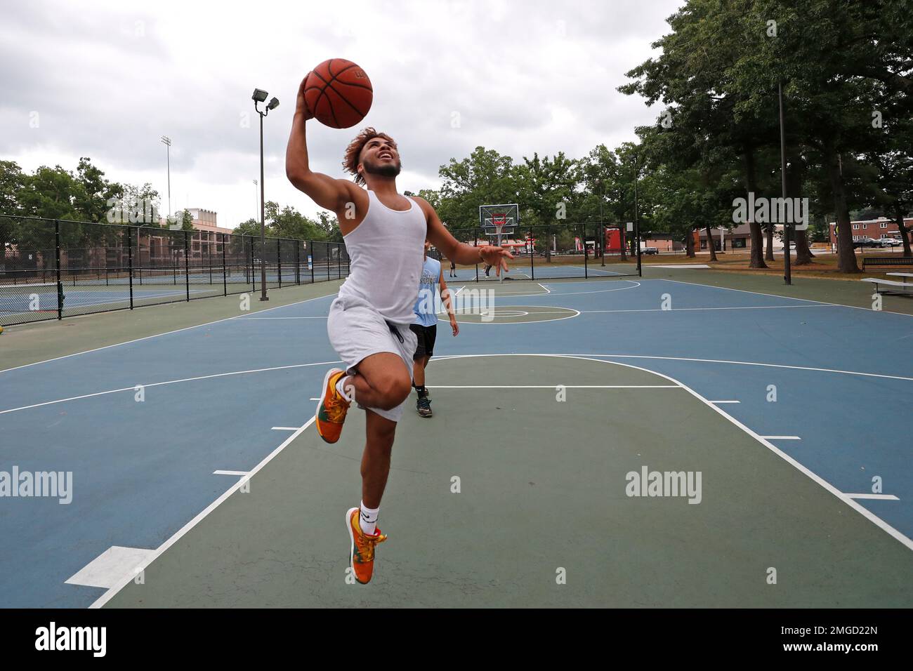 Willdy Santana goes in for a layup on a newly opened basketball court ...