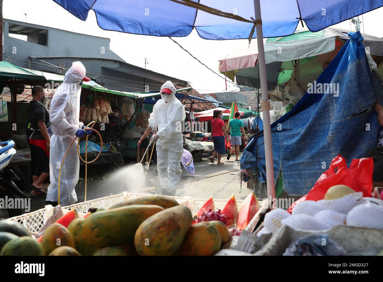 Members of Indonesia Red Cross spray disinfectant in an attempt to help ...