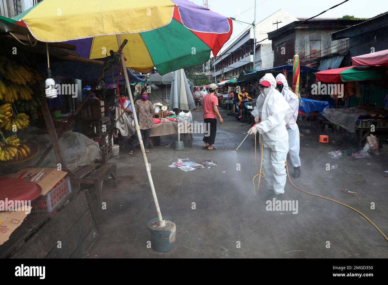 Members of Indonesia Red Cross spray disinfectant in an attempt to help ...