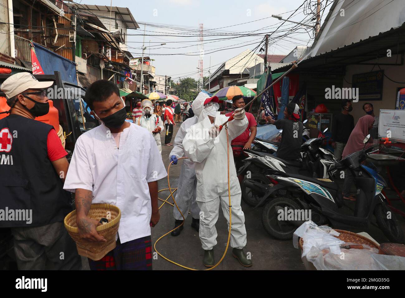 Members of Indonesia Red Cross spray disinfectant in an attempt to help ...