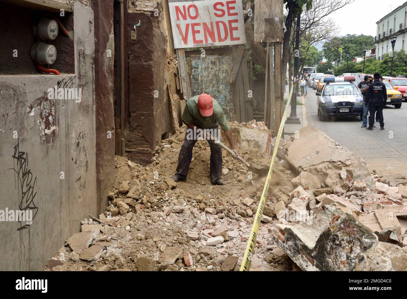 A man removes rubble from a building damaged by an earthquake in Oaxaca ...