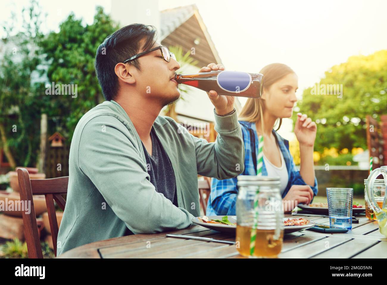 Now that feels good. a young man having a sip of a beer while sitting ...