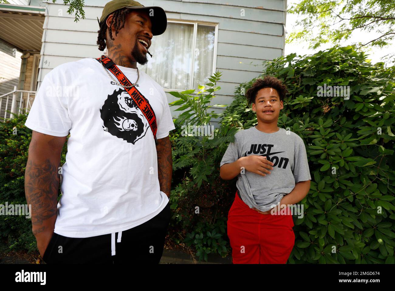 Daylan McLee, left and son Avian, 13, stand on the sidewalk in front of ...