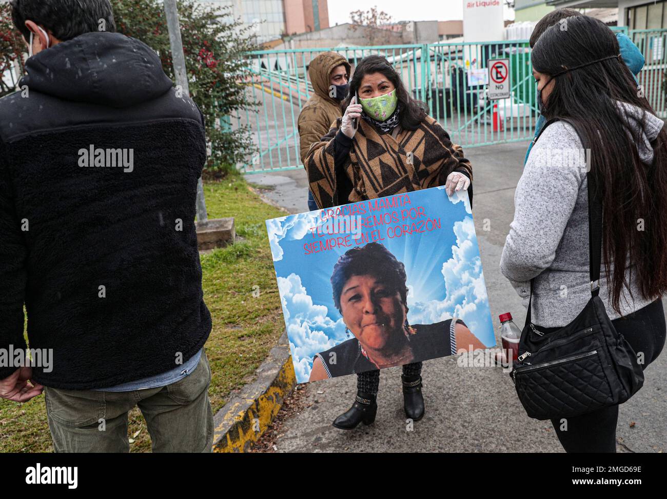 A daughter of Lidia Morales carries a picture of her mother to place ...