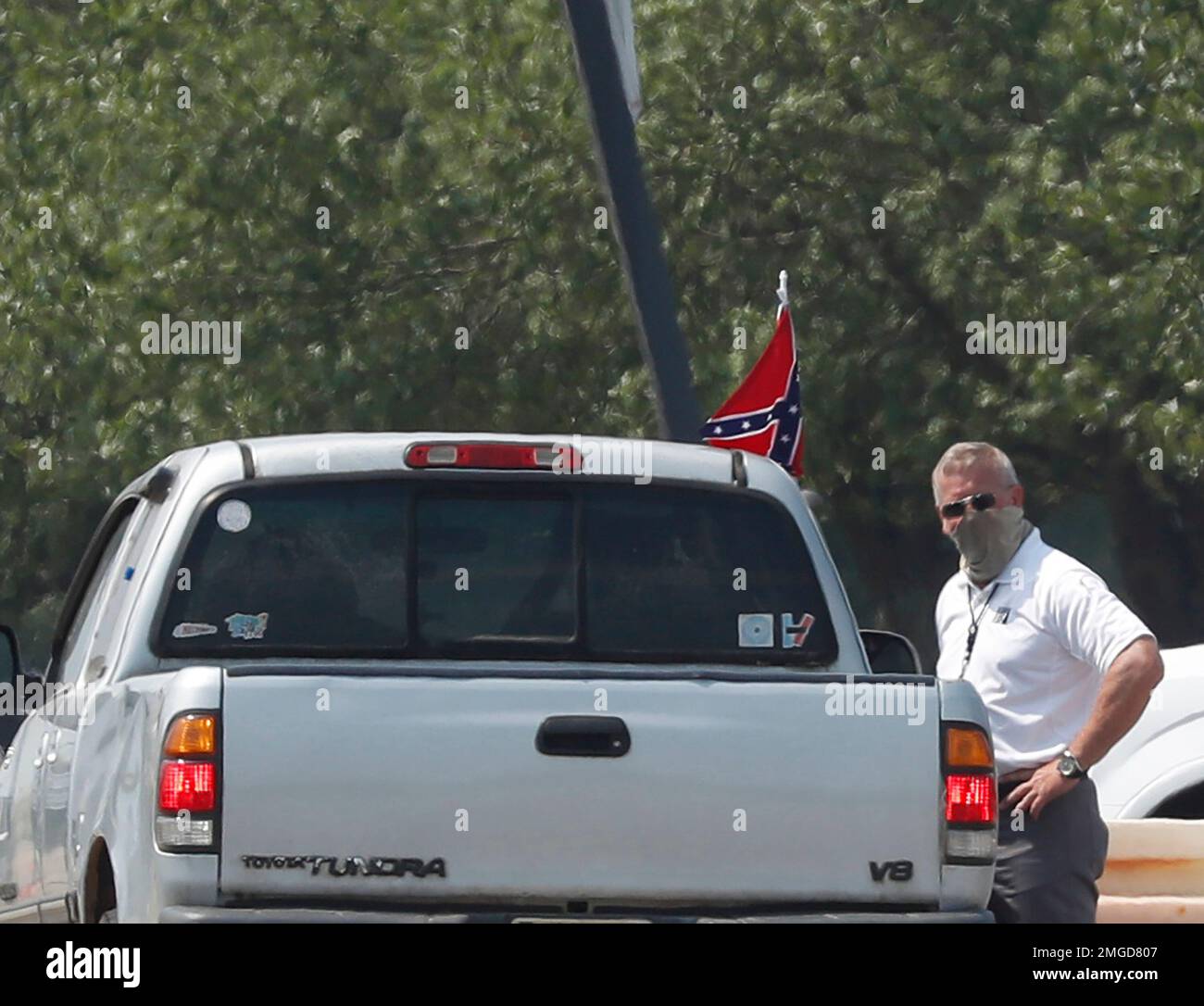 A race fan flying a Confederate battle flag passes through a checkpoint ...