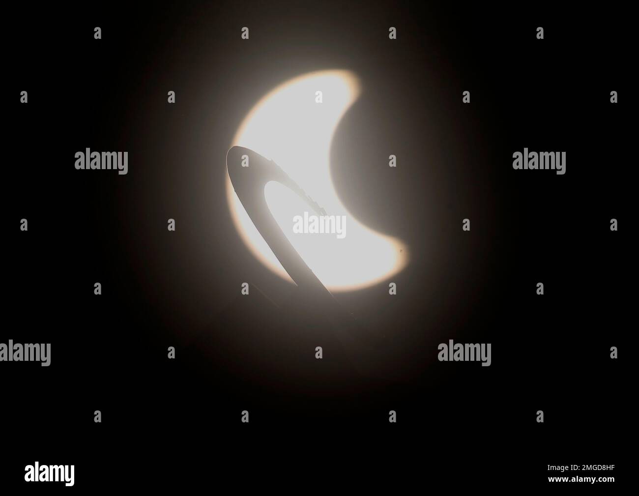 The partial solar eclipse is seen through a crescent fixed on the ...