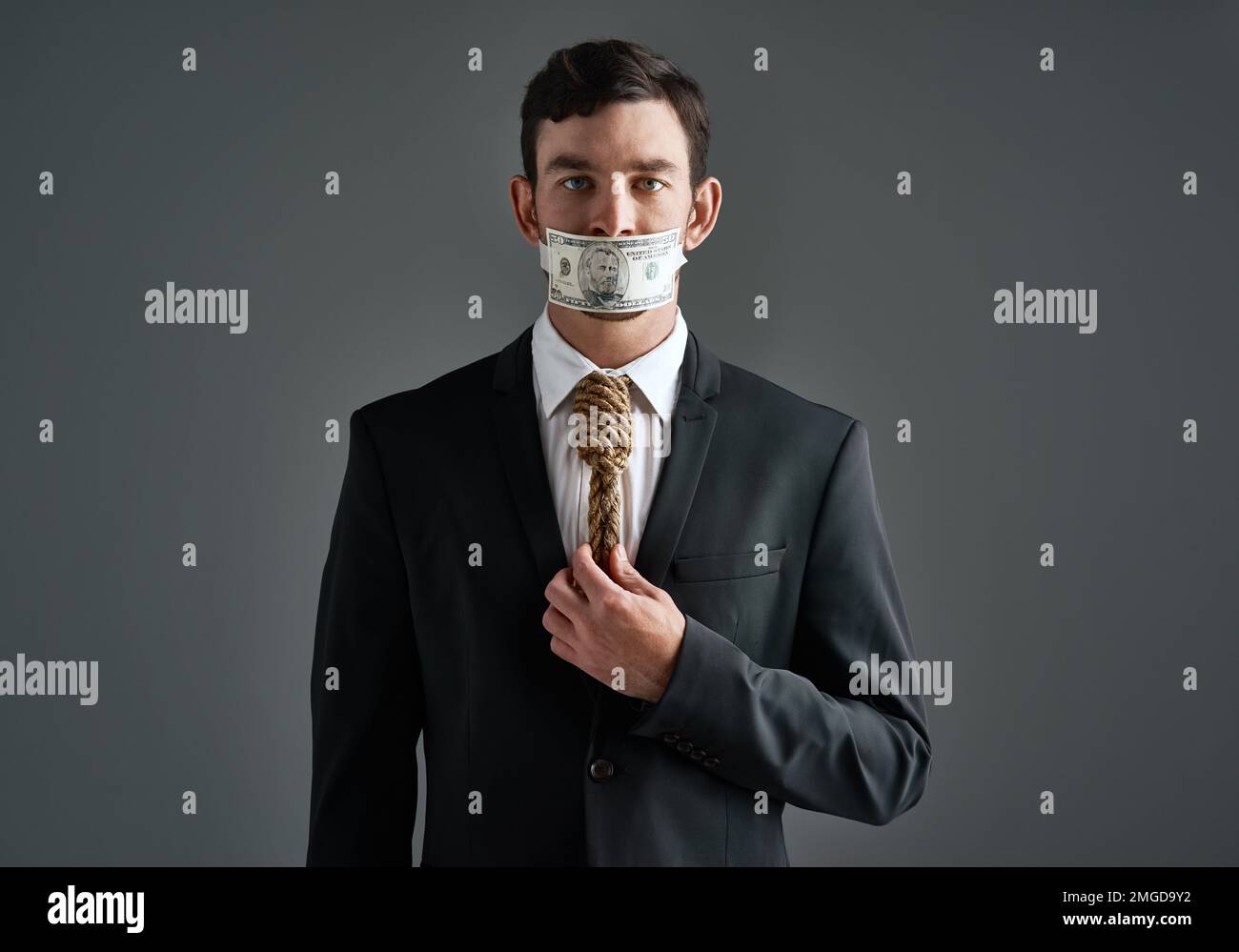 Everyone has a price. Studio portrait of a businessman with rope around ...
