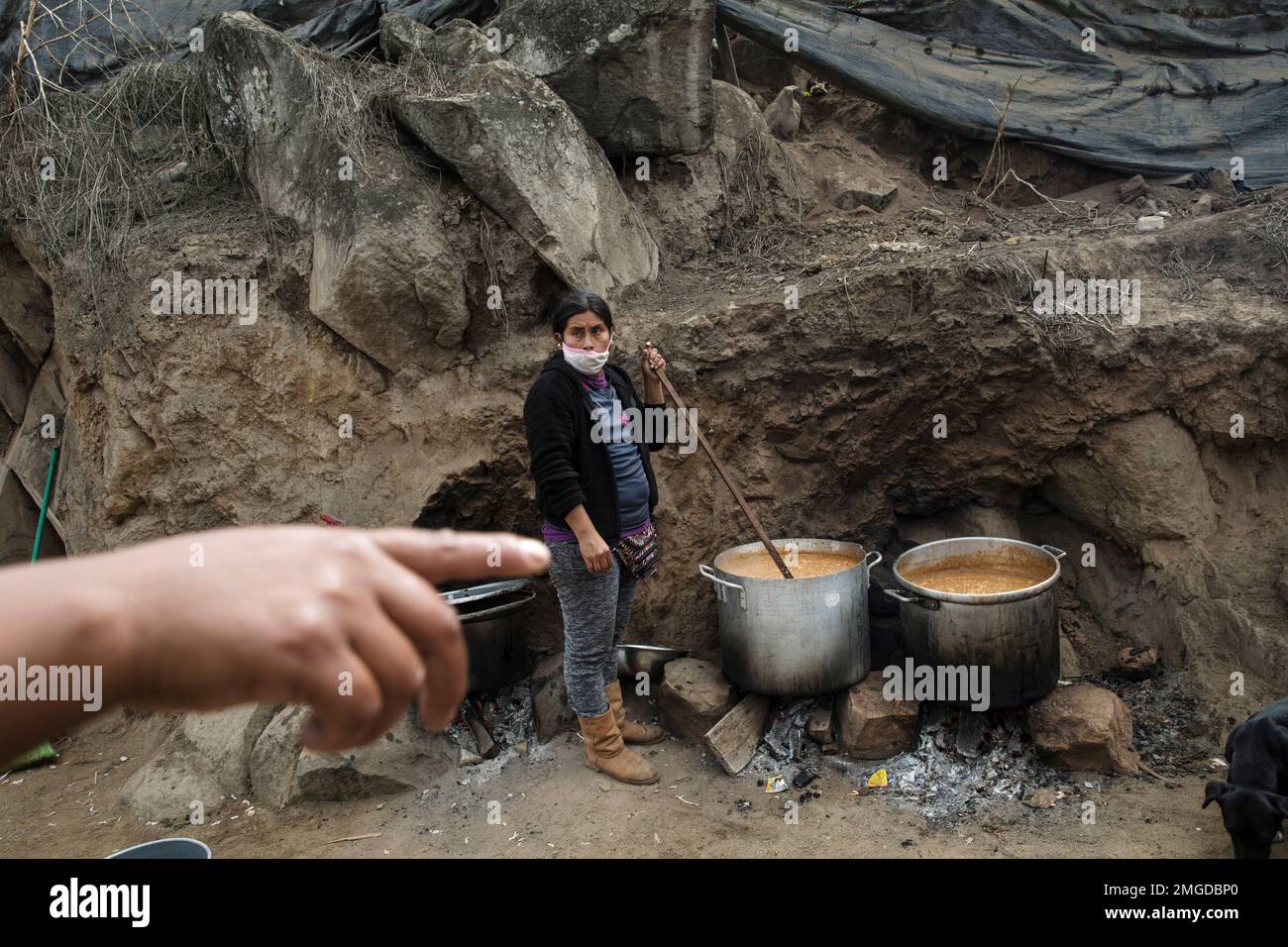 A volunteer keeps watch over pots of simmering "carapulca," an ancient ...