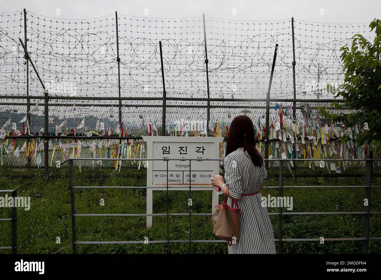 A visitor walks in front of a directional sign showing the distance to ...