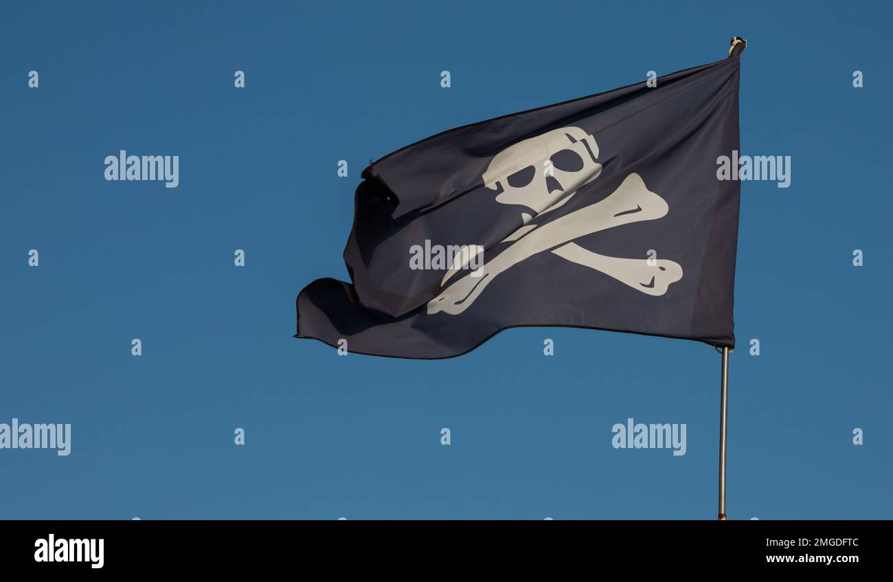 jolly roger. pirate flag.Against the background of blue sky Stock Photo ...