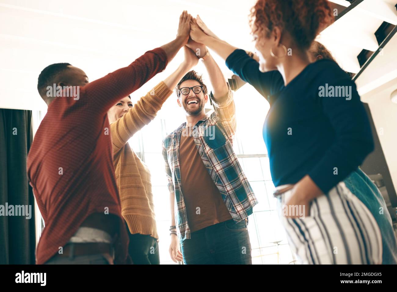 Keep on believing you can. a group of designers high fiving together in ...