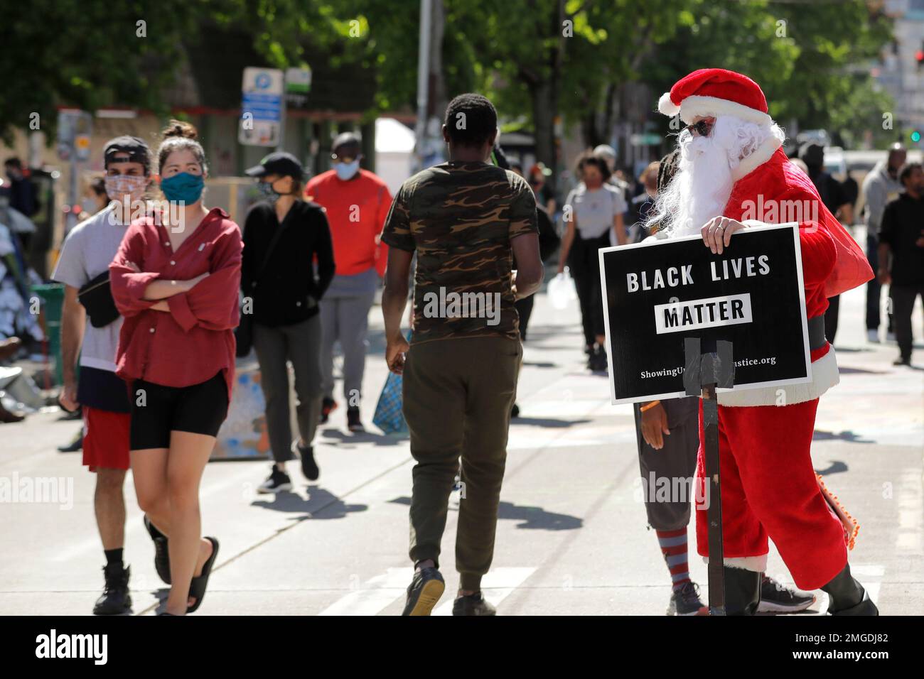 Derrek Dunn carries a Black Lives Matter sign as he walks while dressed ...