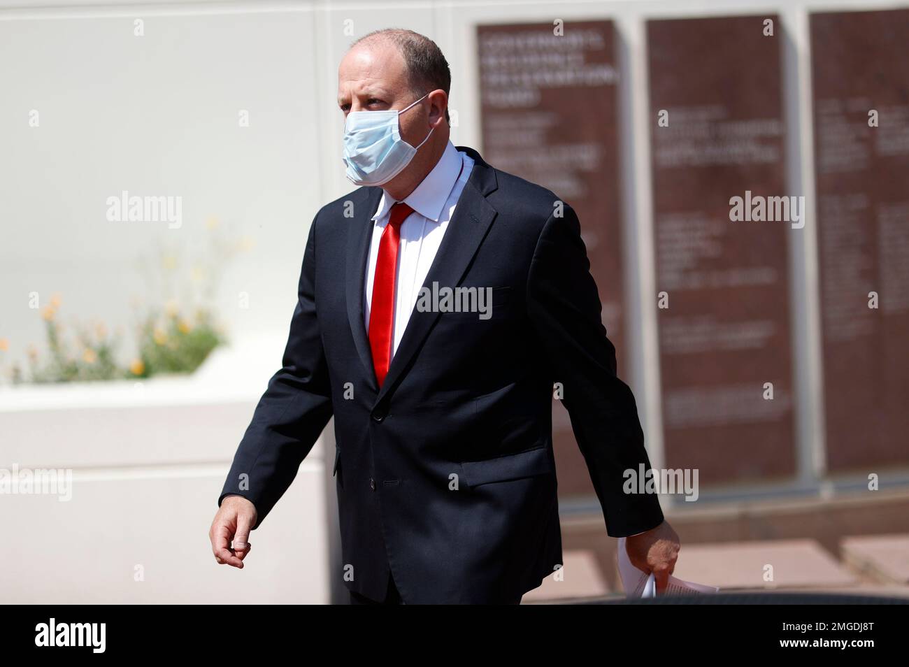 Colorado Governor Jared Polis heads into a news conference on the state ...