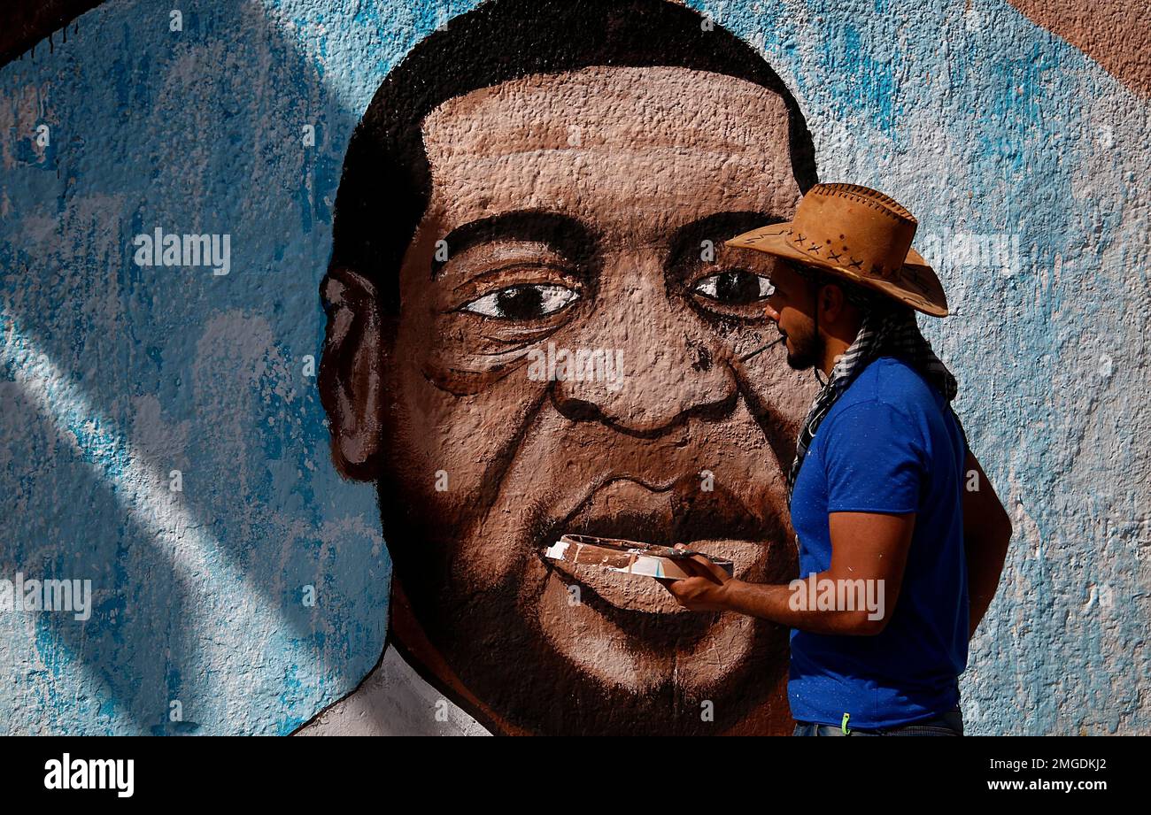 A Palestinian artist paints a mural depicting George Floyd, a black ...