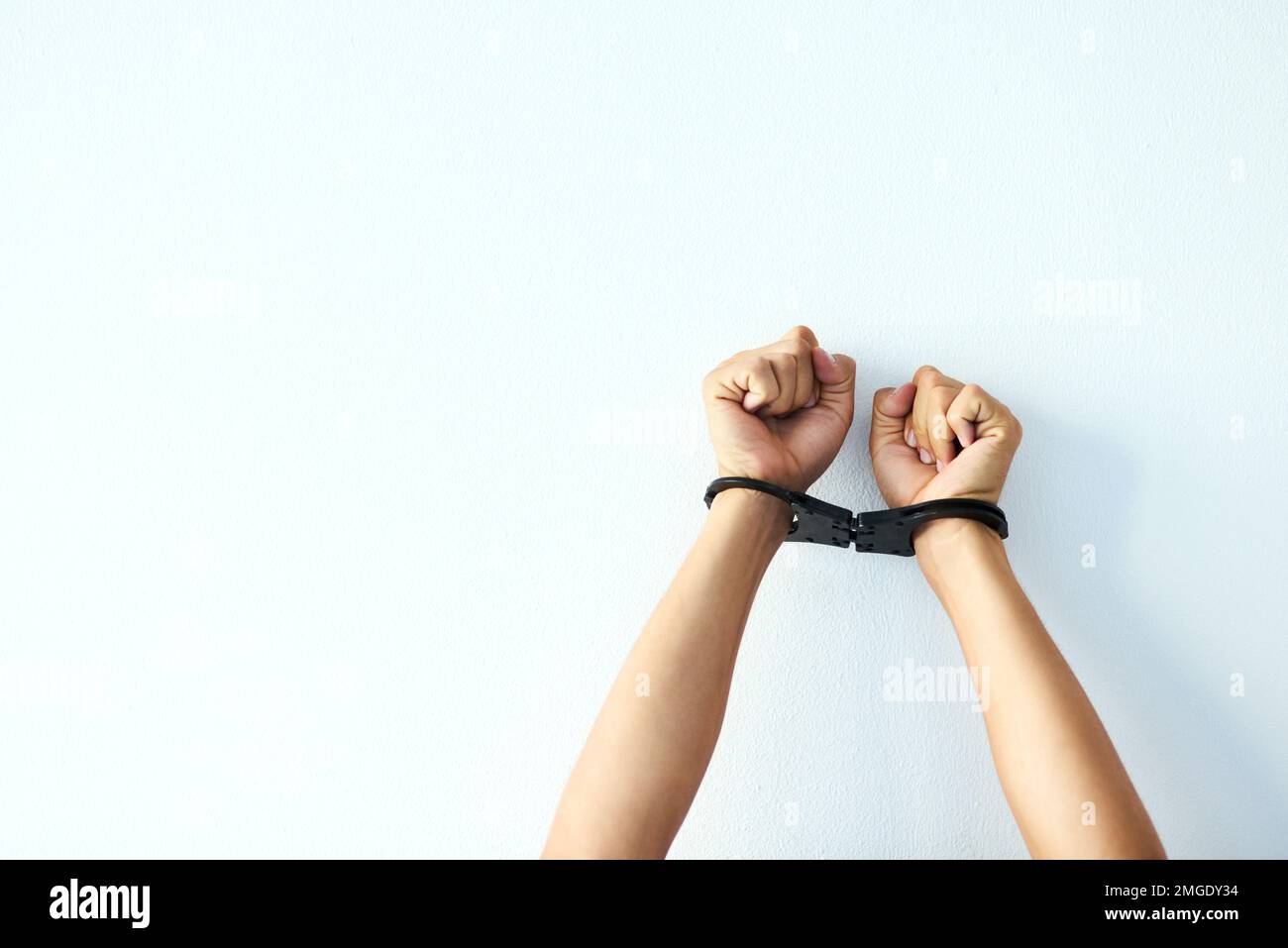 All caught up. Studio shot of an unrecognizable persons hands cuffed ...