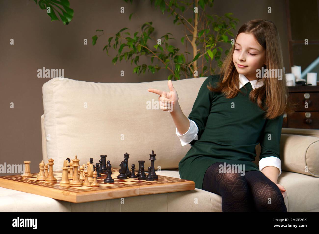 Self-confident teen girl playing logical board game. Young chess player ...