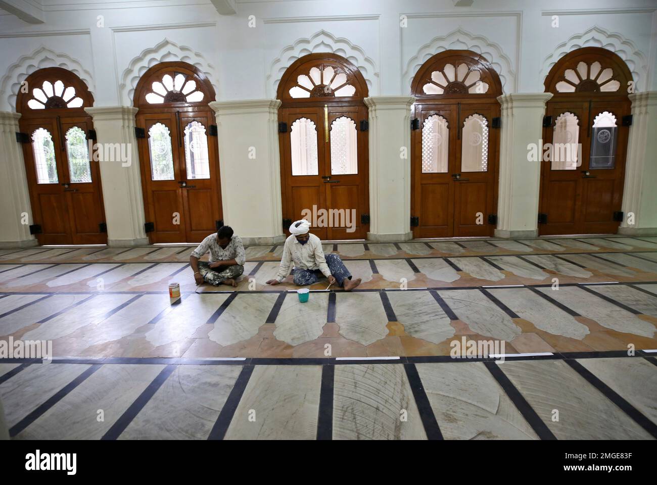Workers put the paint markings indicating worshippers to maintain ...